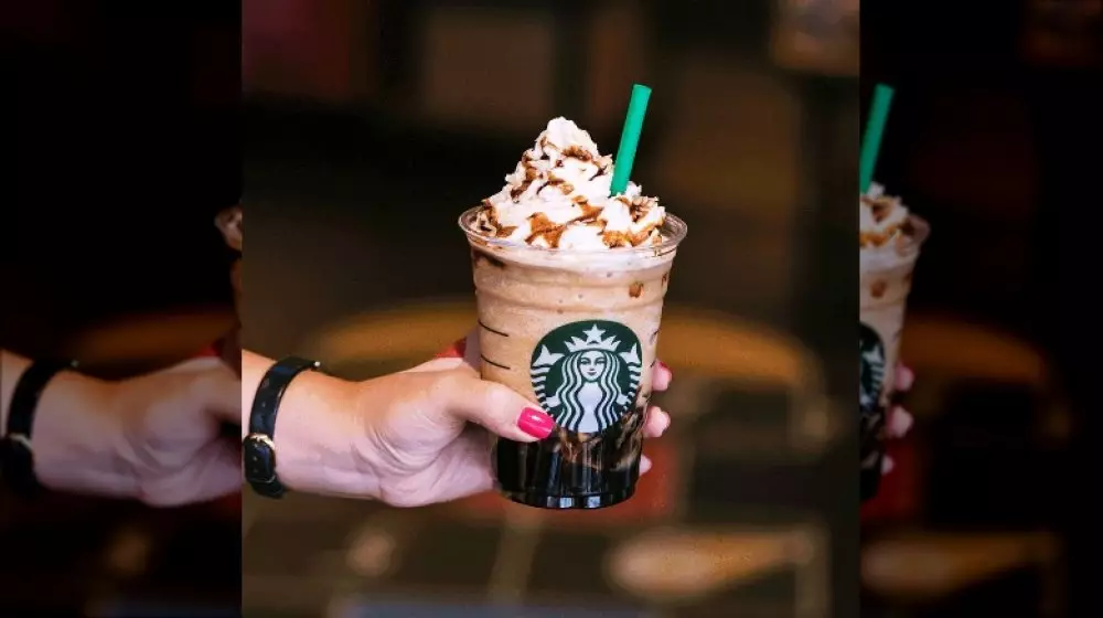 trzyma frappuccino ze starbucksa