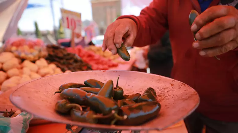 Mann setzt Jalapeños op Skala