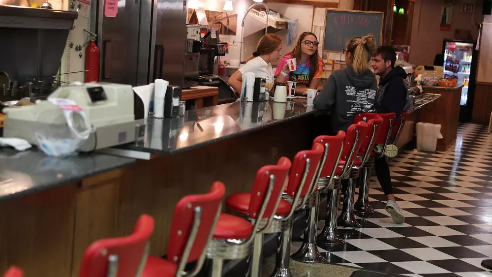 Les gens traînent au comptoir de la fontaine à soda de la pharmacie Montross le 10 octobre 2019 à Winterset, Iowa. Les caucus démocrates de l'Iowa 2020 auront lieu le 3 février 2020, ce qui en fera le premier concours de nomination aux primaires présidentielles du Parti démocrate.