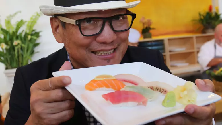 Kuiristo Morimoto tenante teleron da nigiri-suŝio