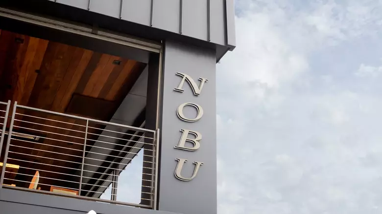 Papan tanda Nobu di restoran terbuka di sebelah langit