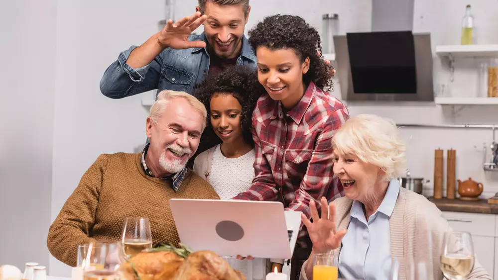 Семейство с лаптоп на вечеря за Деня на благодарността
