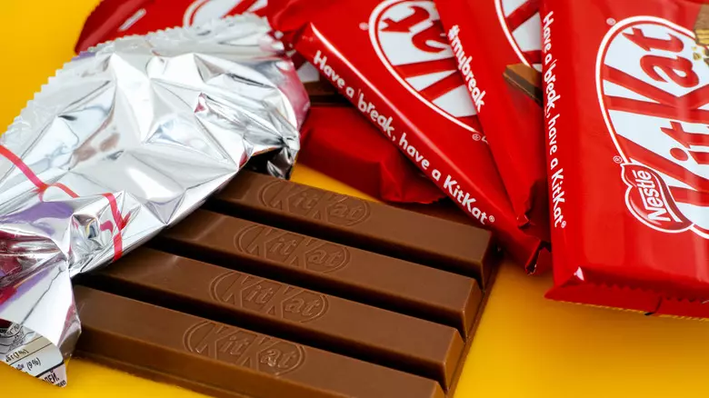 Μια ξετυλιγμένη μπάρα KitKat μπροστά από μια στοίβα σοκολάτας