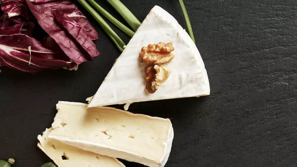 Een wedge en plakjes Brie met garnituur