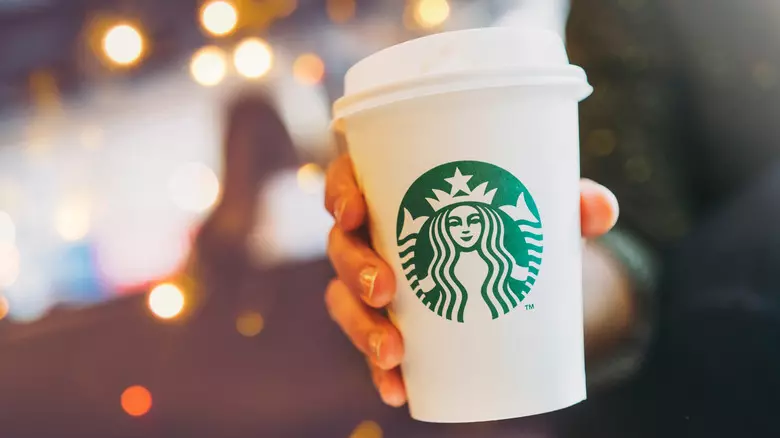 Starbucks kofje beker yn persoan syn hân