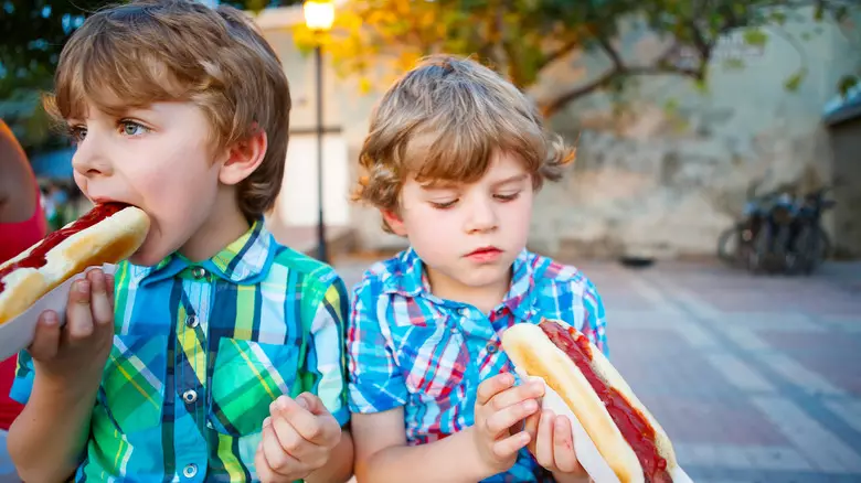 Kinderen die hotdogs eten