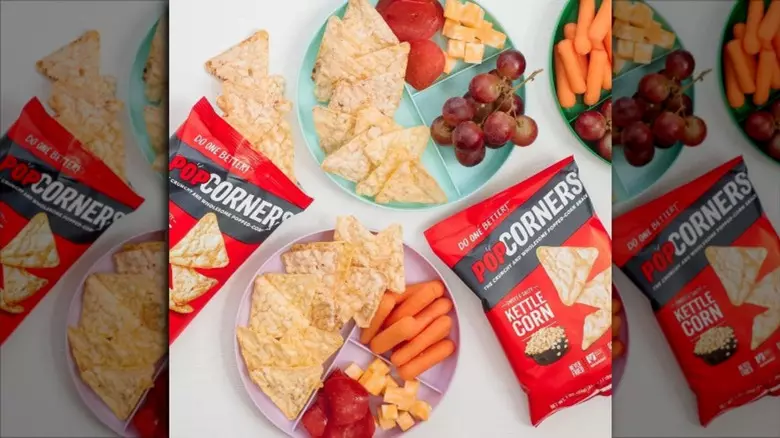 Chips de maíz hervidor PopCorners en bandeja de aperitivos con frutas y verduras