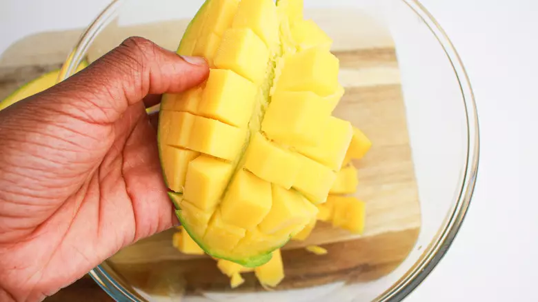 Una mà que subjecta mango tallat