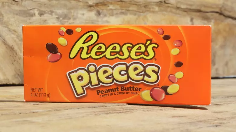 Cutie de Reese's Pieces pe suprafață de lemn