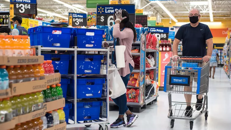 maskerad man och personal handlar i Walmarts matbutik