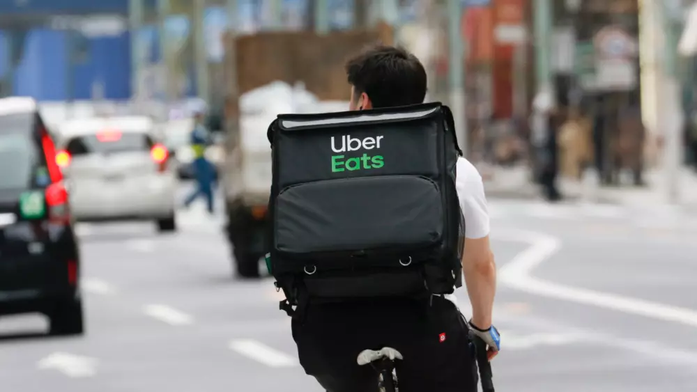 Persona in bicicletta con una borsa Uber Eats