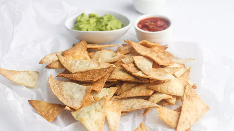 Guac va salsa bilan plastinkada tayyor tortilla chiplari