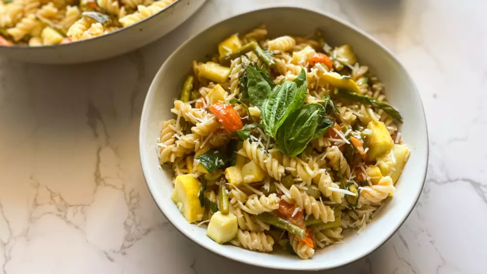 Pasta Primavera mit Nudeln Zucchini und Tomaten in weißer Schüssel