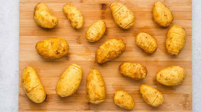 patates hasselback sobre una taula de tallar