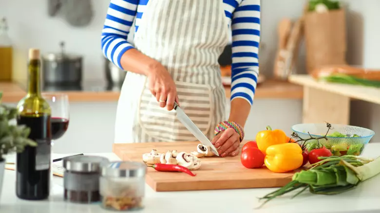 vrouw maakt groenten klaar om te koken met rode wijn