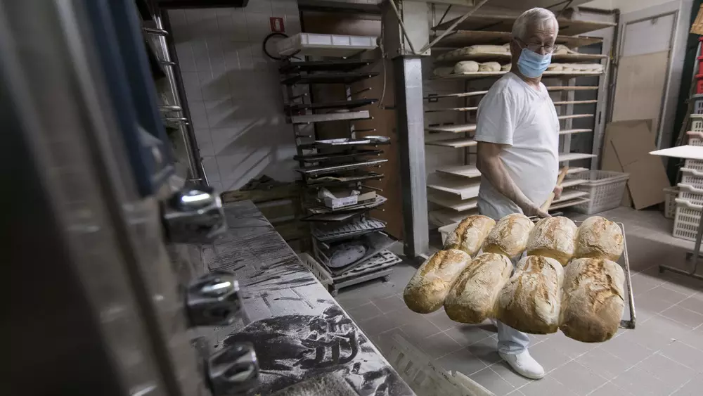 Boulanger exhibant des pains sortis du four