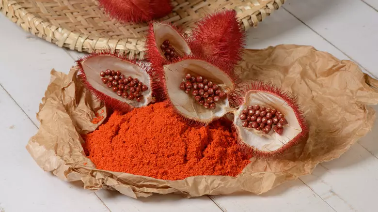 Annatto dikisar dan dalam buah pada kertas perang yang renyuk