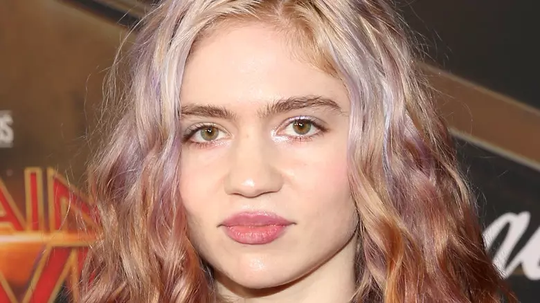 Grimes glimlag op rooi tapyt