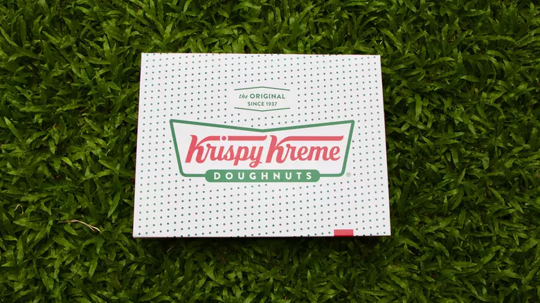 Кутия Krispy Kreme понички върху трева