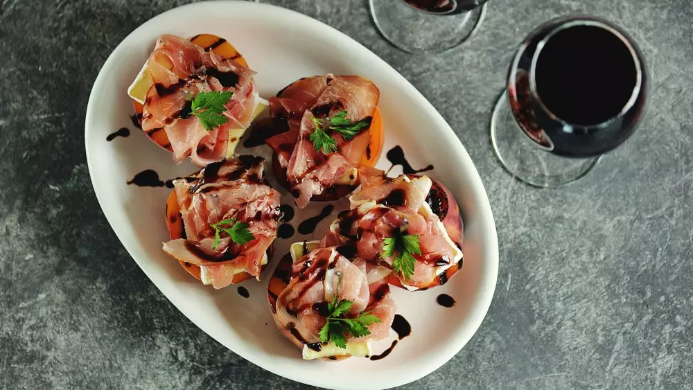 Geroosterde perskes bedek met kaas, prosciutto en balsamiese glans