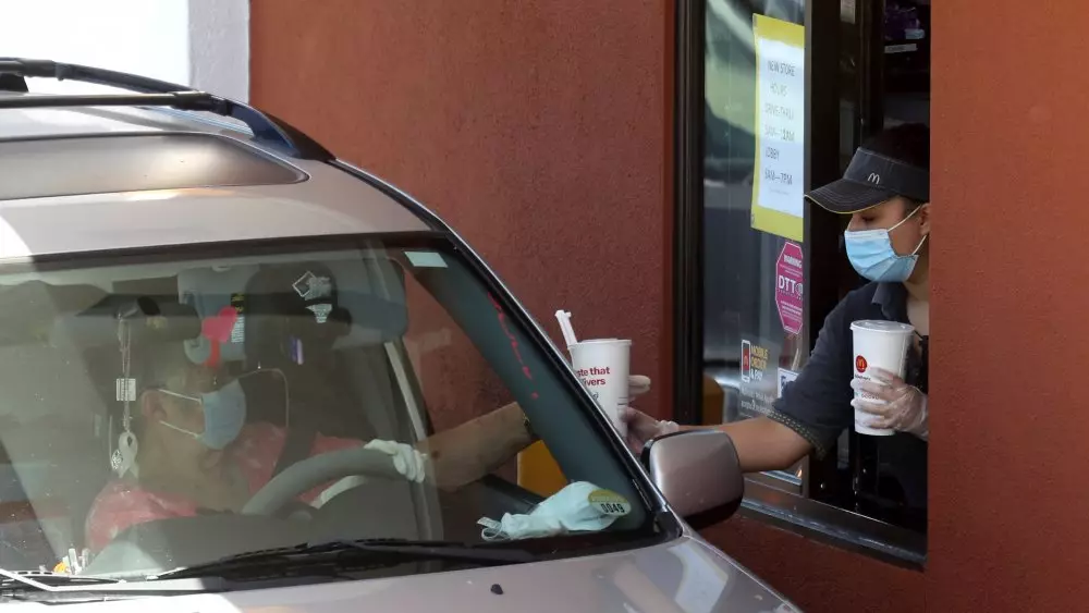 McDonald's-meiwurker mei masker en wanten tsjinnet klant yn drive-thru