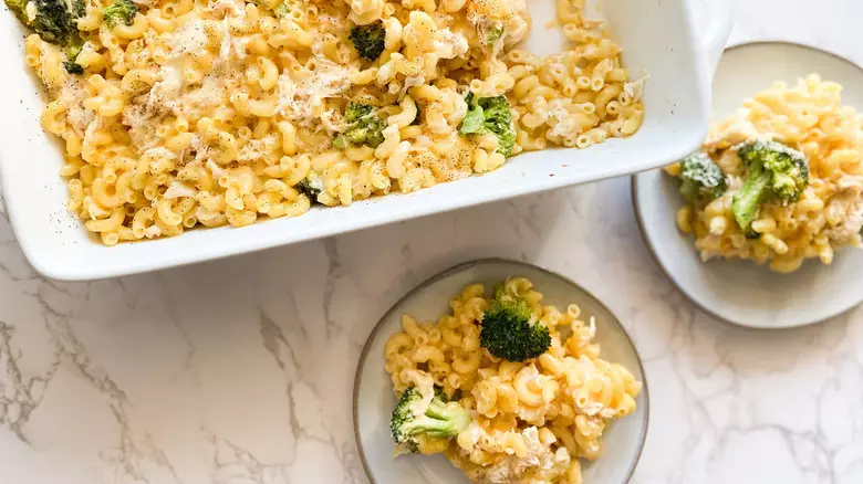 bagning fad fuld af kylling broccoli mac og ost serveret på to tallerkener