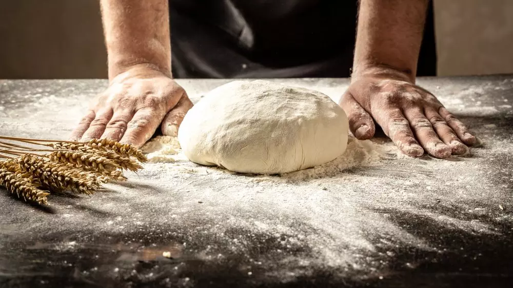 Unlu tahta üzerinde ekmek yoğurma