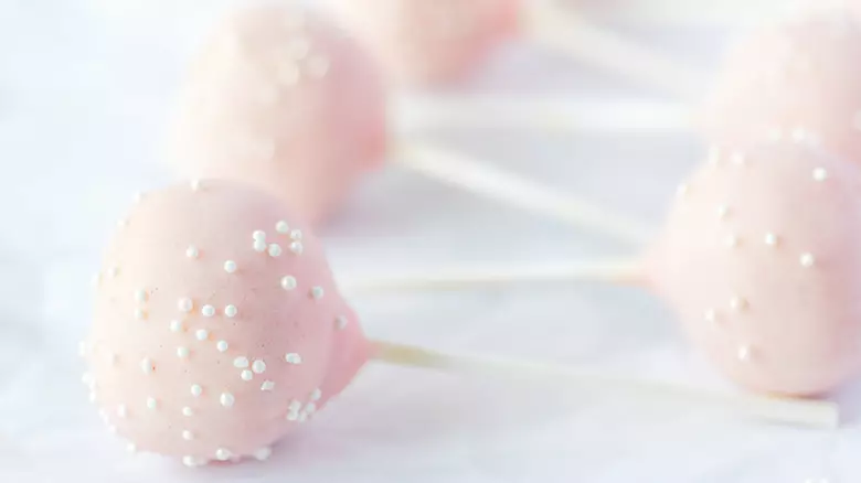 cake pops recubertos de chocolate rosa con chispas brancas