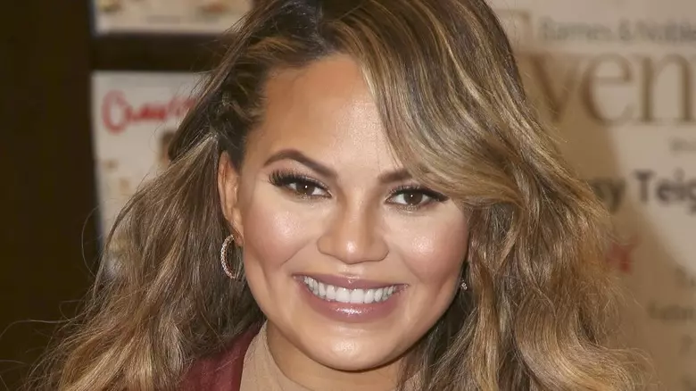 Chrissy Teigen se smeji s spuščenimi lasmi