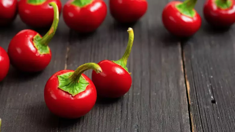 Poivrons cerises sur table en bois sombre