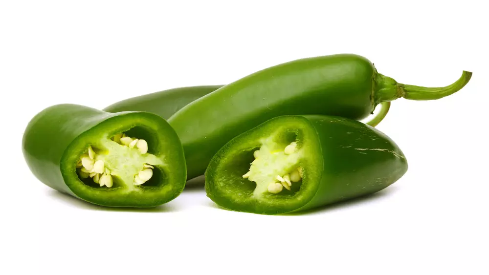 primer plano de pimientos jalapeños enteros y en rodajas