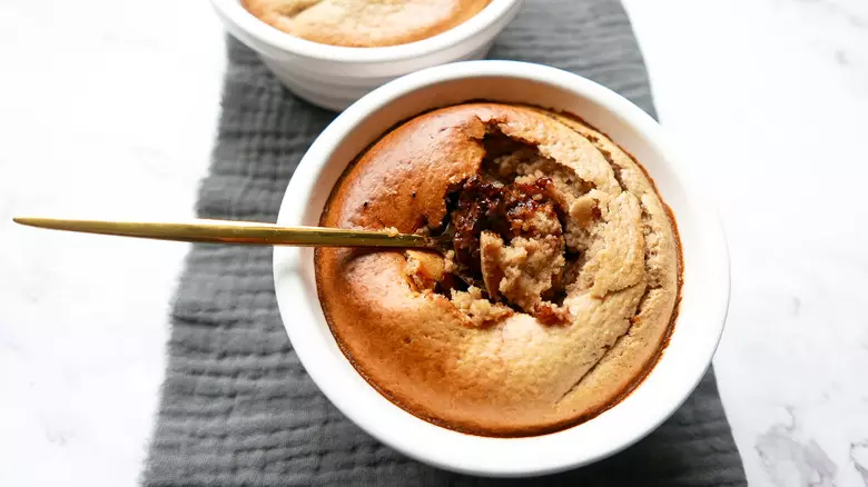 ramekin දී බේක් කරන ලද oatmeal සමග හැන්දක් කඩා දැමීම