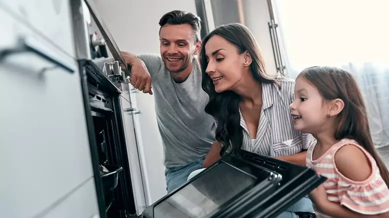 familia mirando a torta no forno